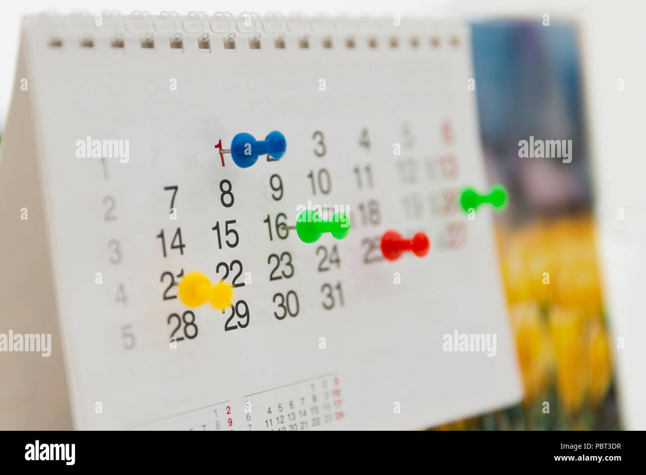 Colorful pins push marking on a calendar. Busy schedule Stock Photo - Alamy