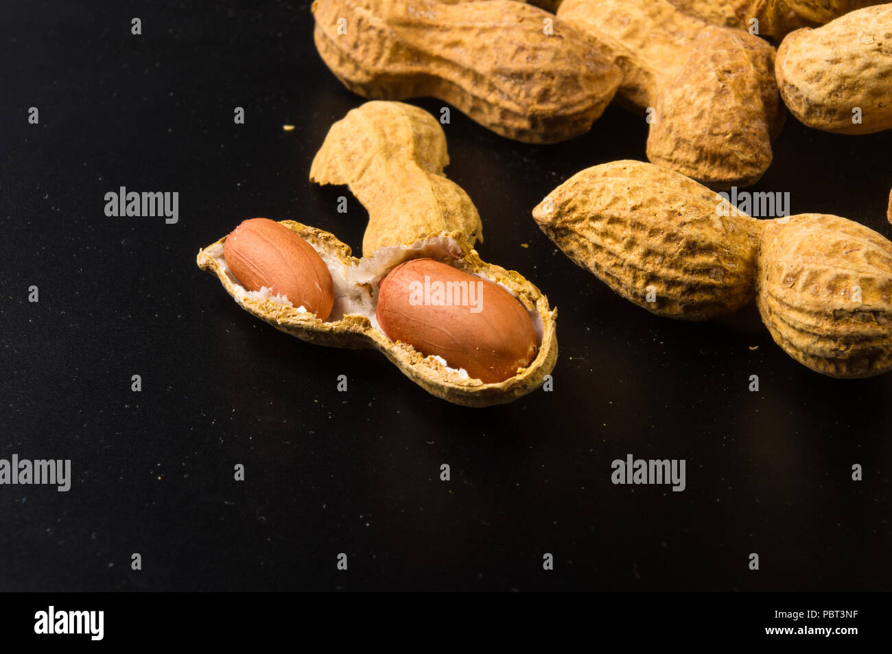 Peanuts in shell on dark background, close up Stock Photo - Alamy