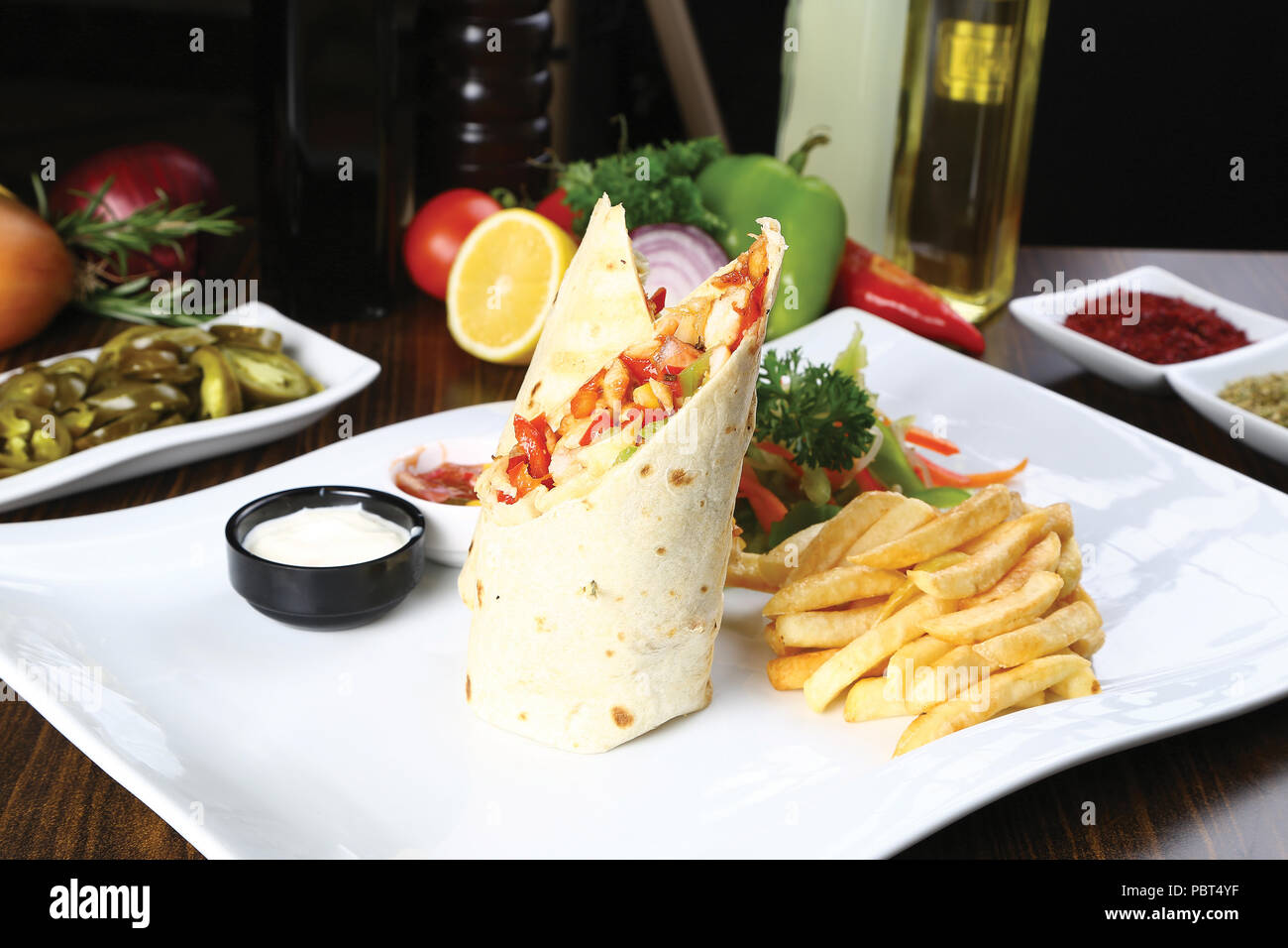 Fried chicken stuffed tortilla wrap sandwich with vegetables and french ...