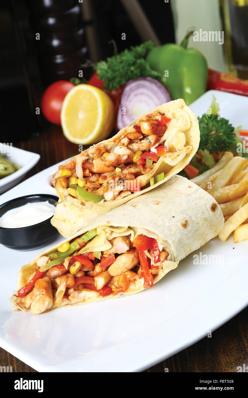 Fried chicken stuffed tortilla wrap sandwich with vegetables and french ...
