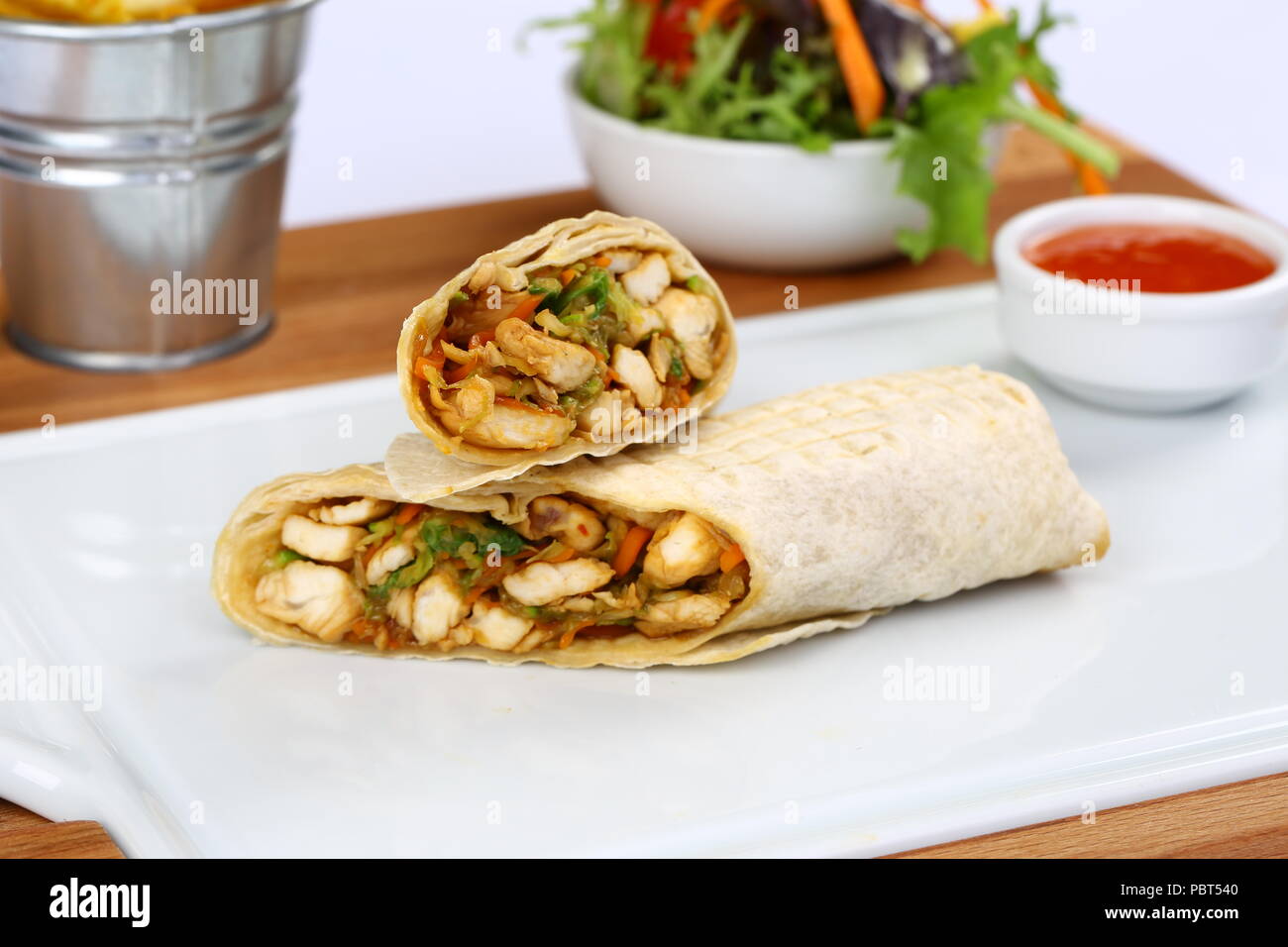 Fried chicken stuffed tortilla wrap sandwich with vegetables and french ...