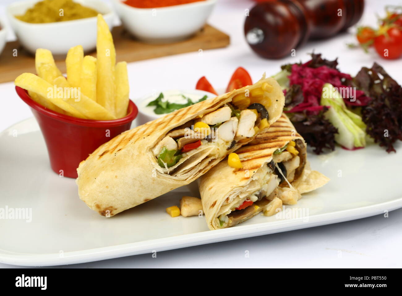 Fried chicken stuffed tortilla wrap sandwich with vegetables and french ...