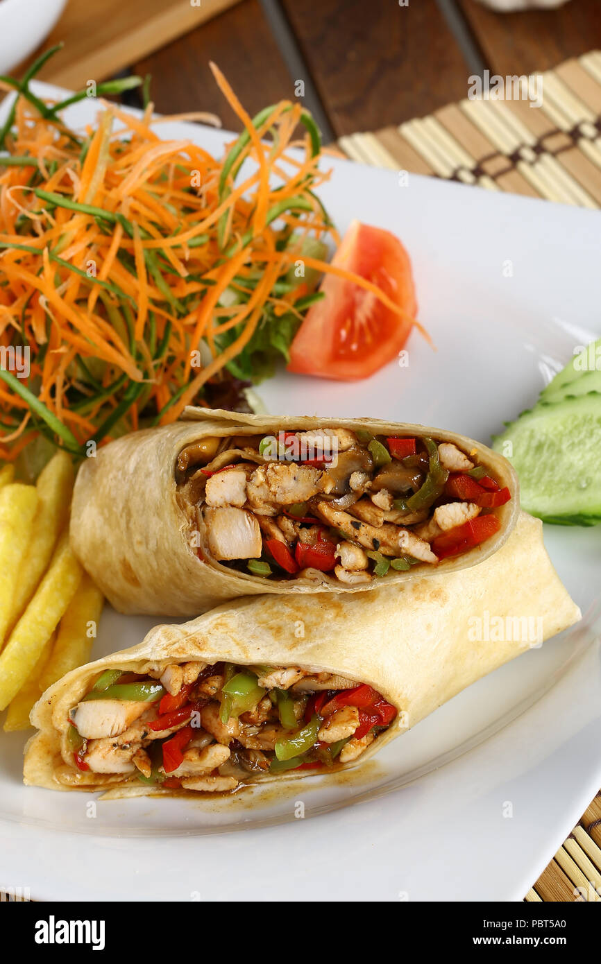 Fried chicken stuffed tortilla wrap sandwich with vegetables and french ...