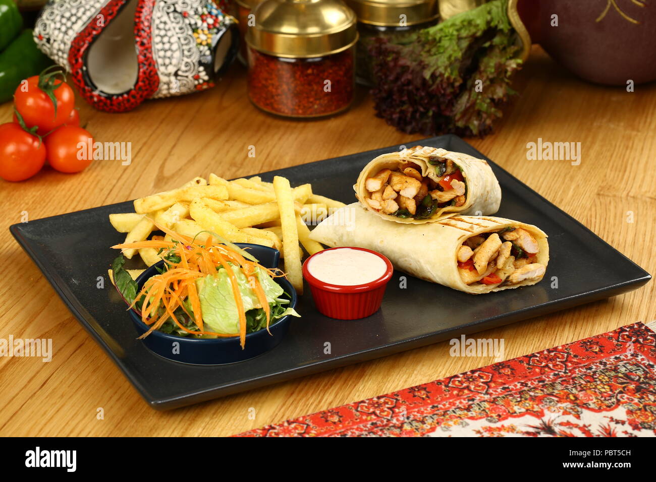 Fried chicken stuffed tortilla wrap sandwich with vegetables and french ...