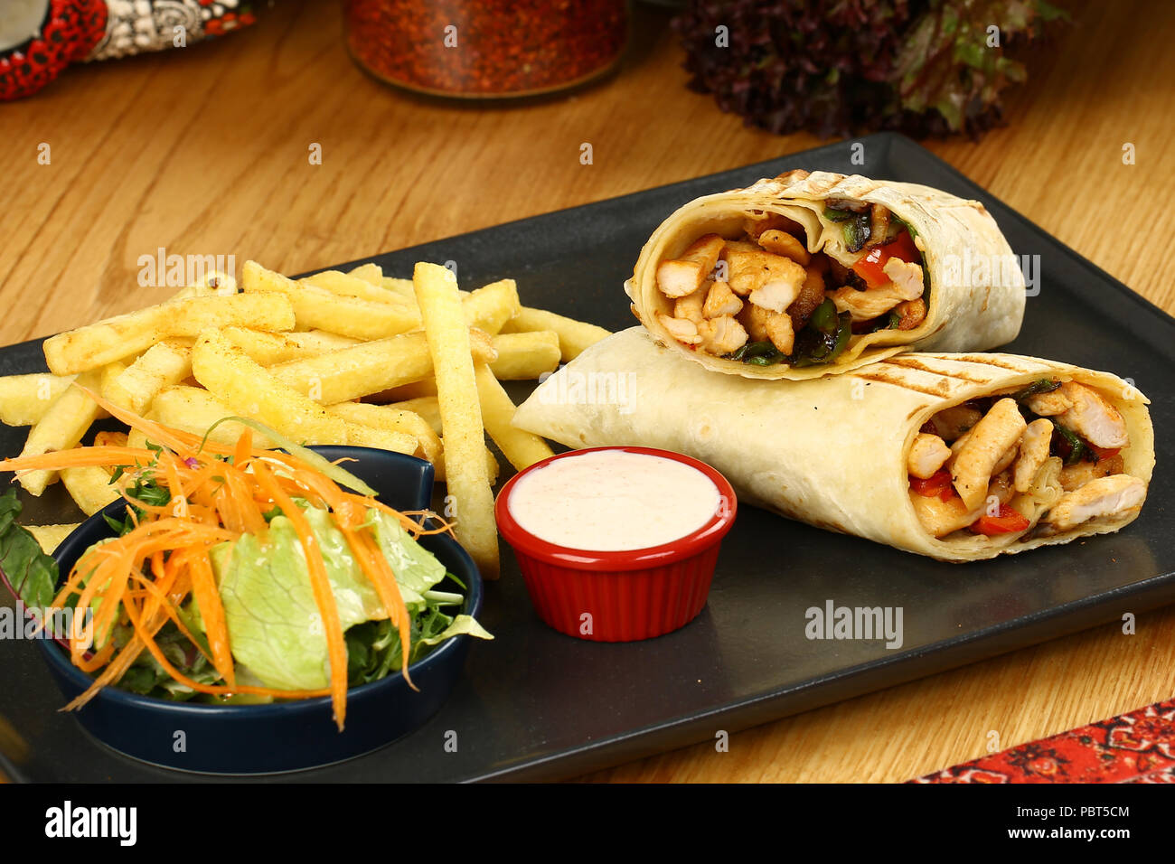 Fried chicken stuffed tortilla wrap sandwich with vegetables and french ...