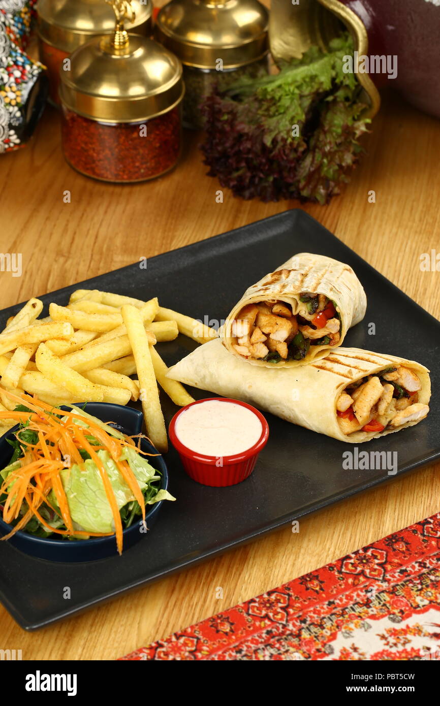 Fried chicken stuffed tortilla wrap sandwich with vegetables and french ...