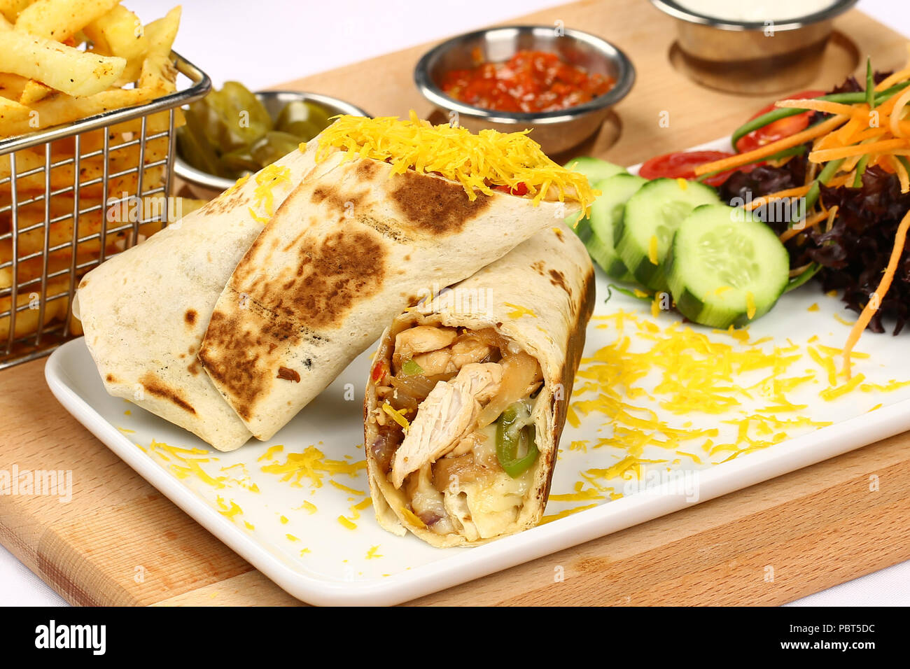 Fried chicken stuffed tortilla wrap sandwich with vegetables and french ...