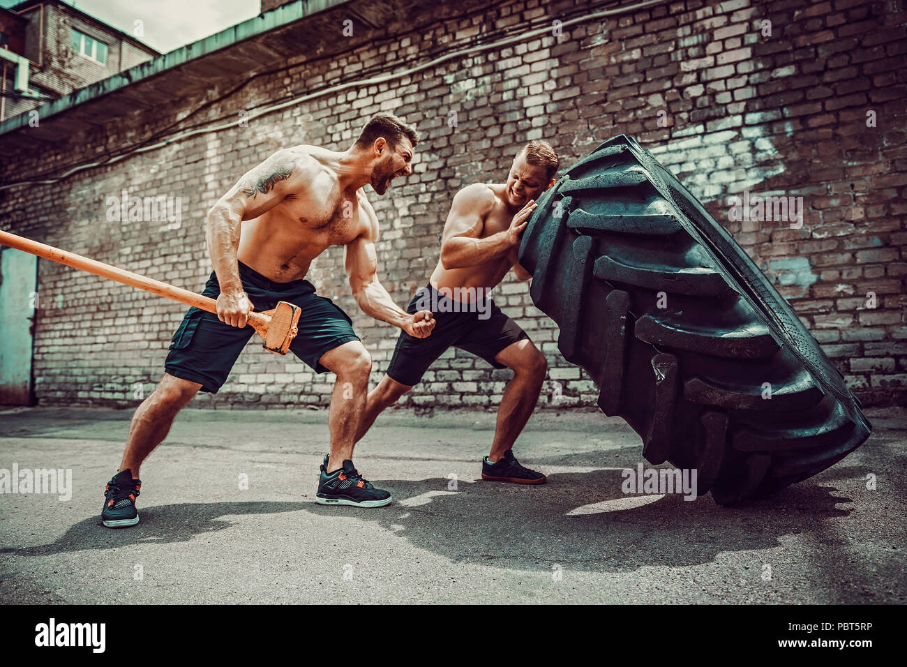 Two muscular athletes training. Muscular fitness shirtless man moving ...