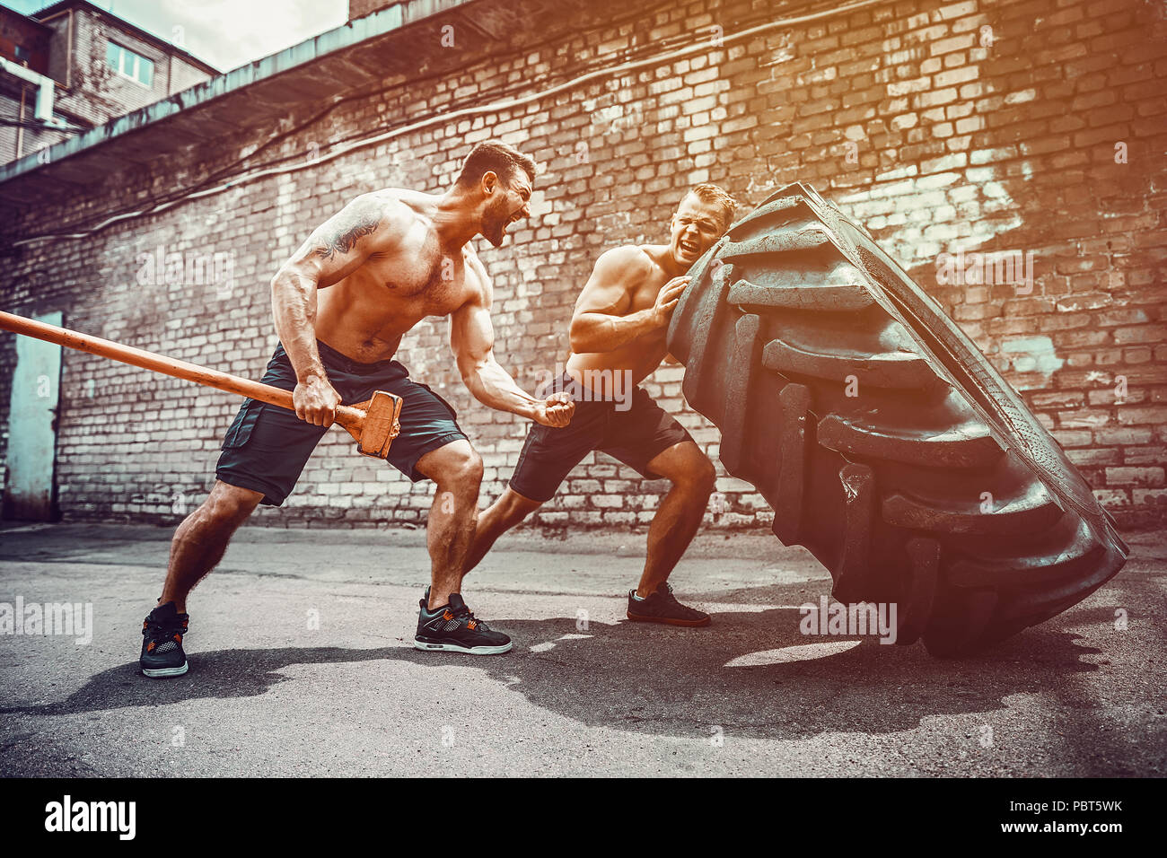Two muscular athletes training. Muscular fitness shirtless man moving ...