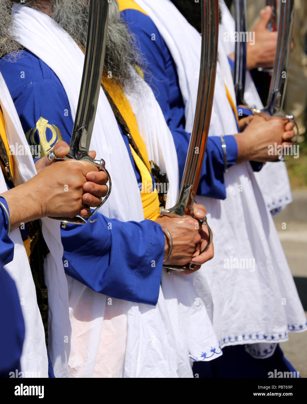Sikh soldiers dressed in traditional white and blue clothes hold curved ...