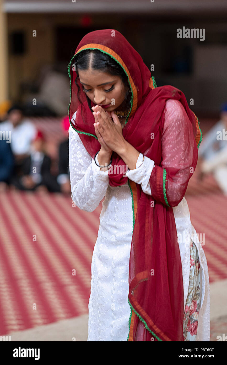 A beautiful wedding guest prays and meditates before the ceremony at a ...