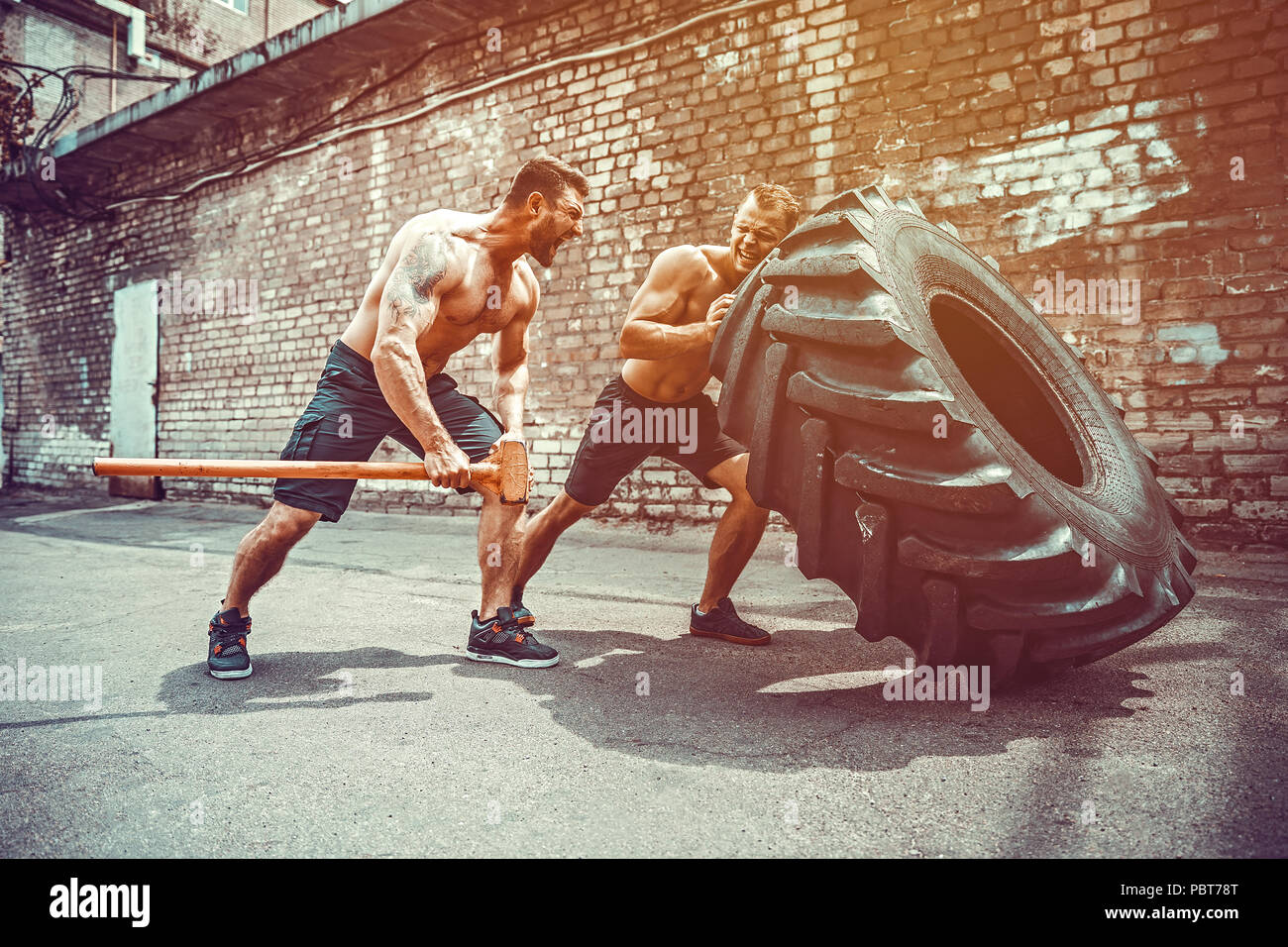 Two muscular athletes training. Muscular fitness shirtless man moving ...