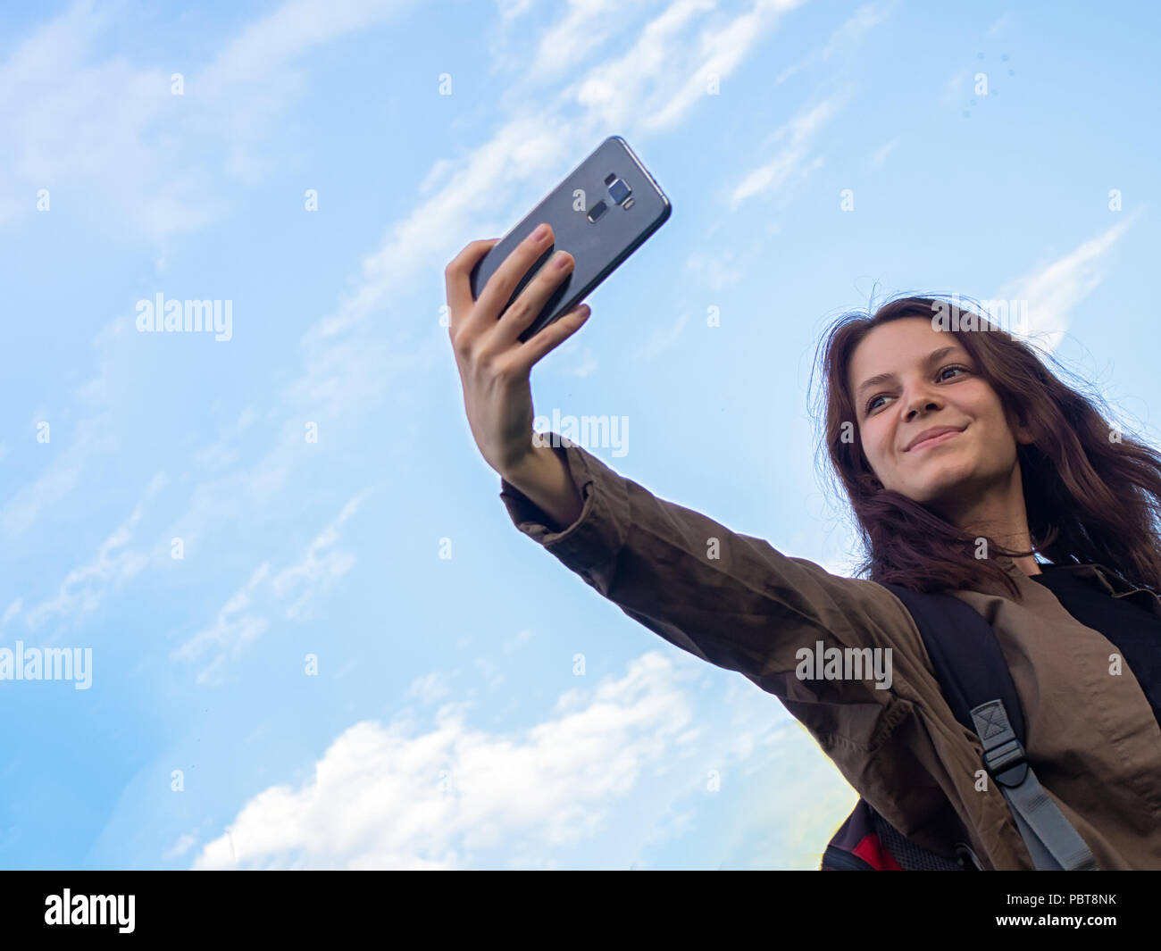 Making selfie happy girl (dutch angle composition) on the sky ...