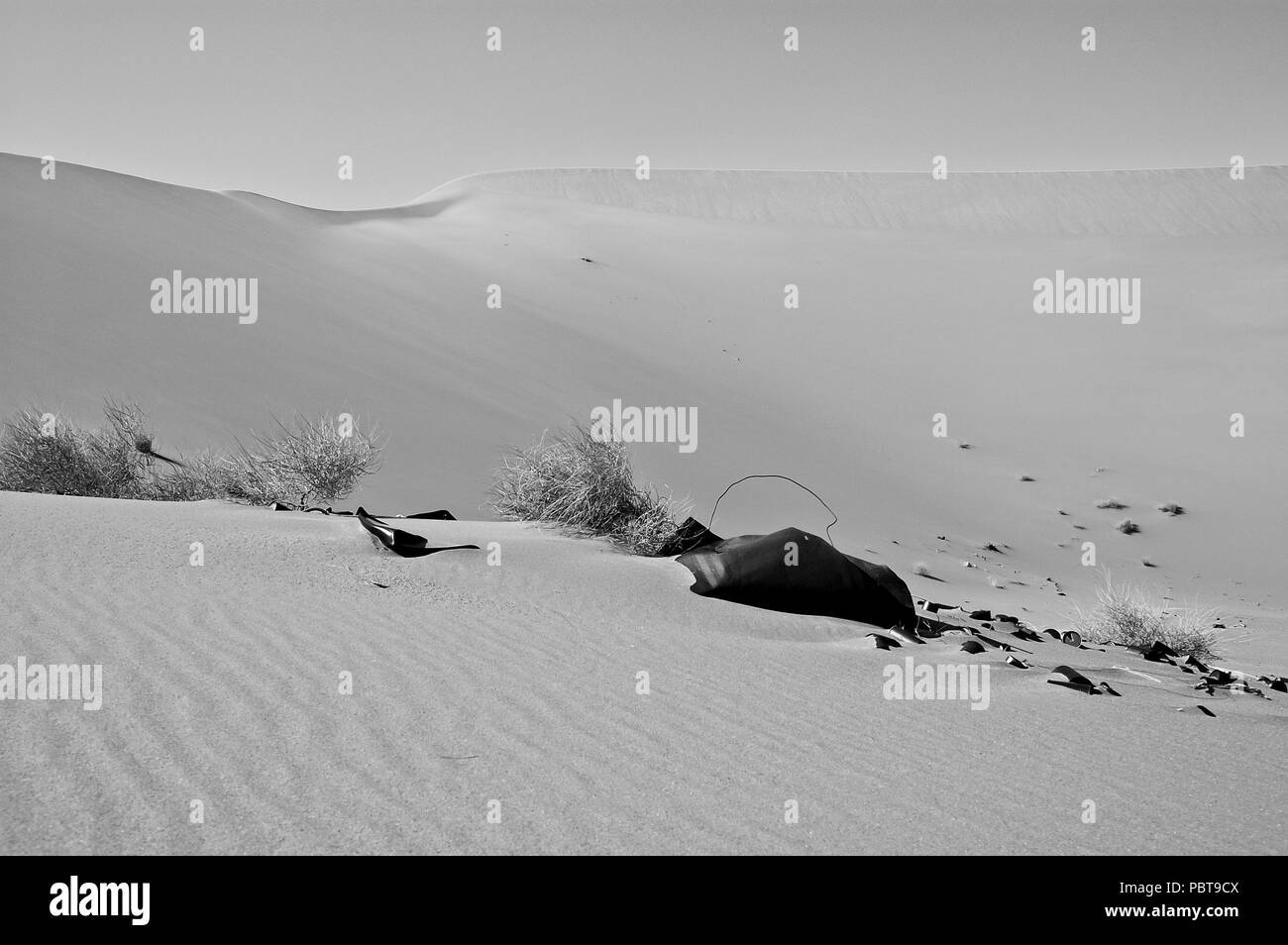 Rusty cans and barrel on the sand in the desert Stock Photo - Alamy