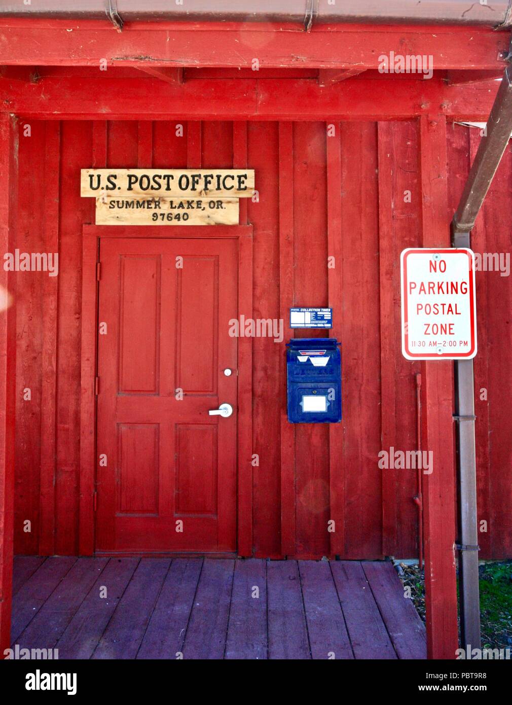 Yellow post office sign on red door with blue postbox hi-res stock ...