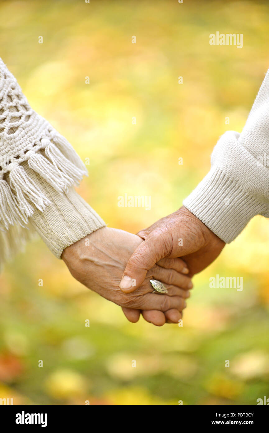 Elderly couple holding hands Stock Photo - Alamy