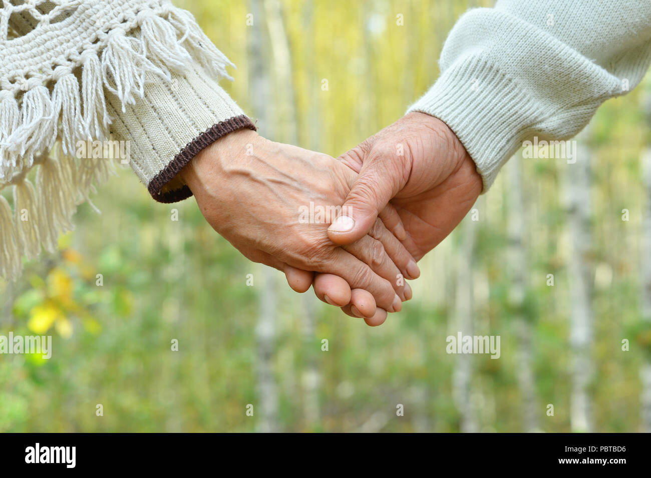 Elderly couple holding hands Stock Photo - Alamy