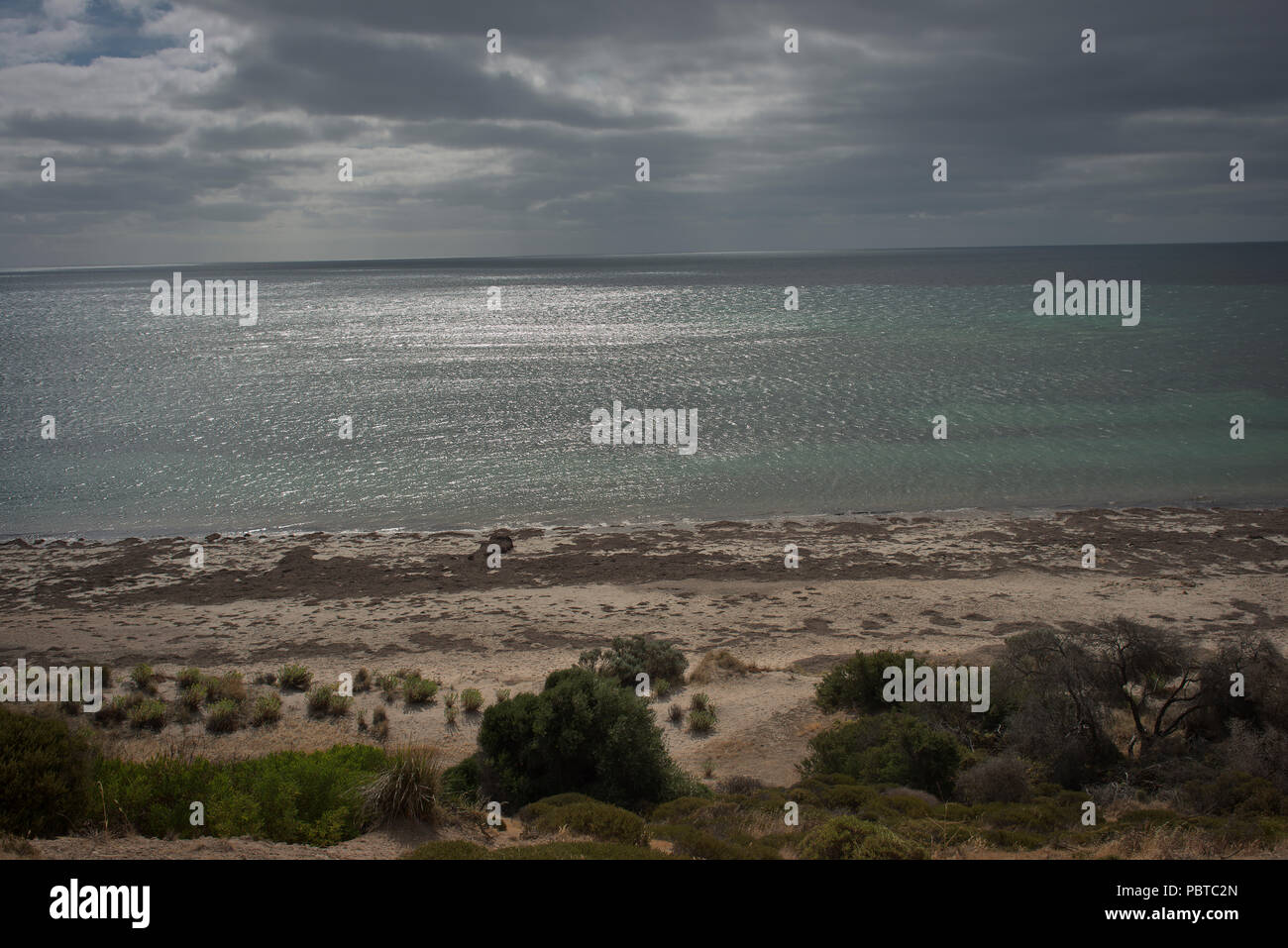 Sea view and reflections with remote bush land Stock Photo - Alamy