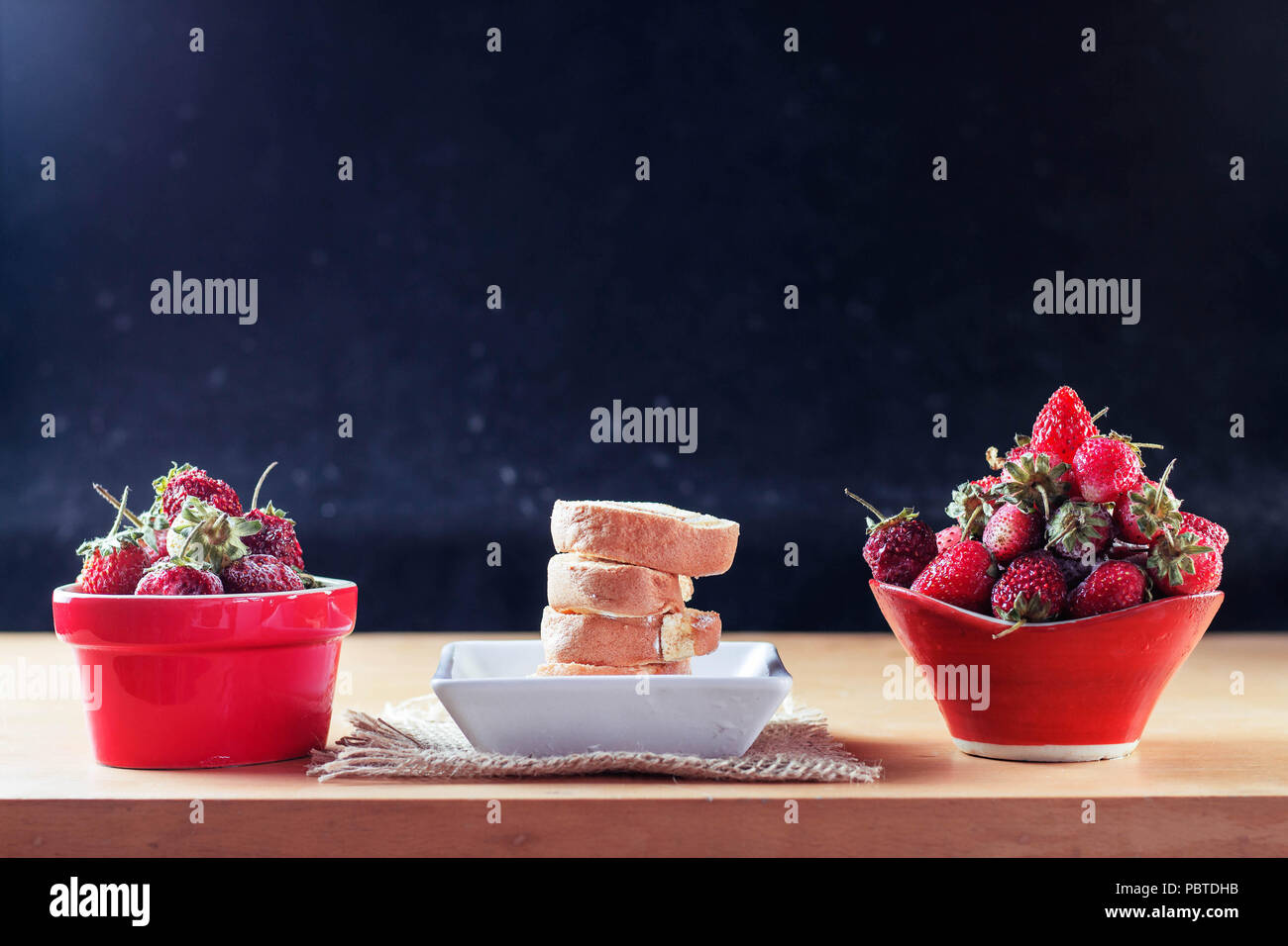 Roll cake and strawberries in the plate on a wooden table Stock Photo ...