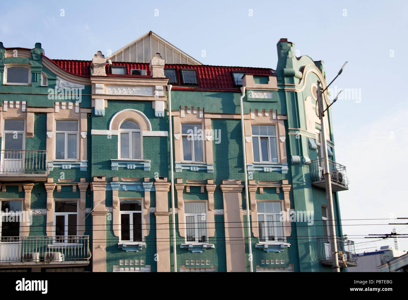 Turquoise building facade with beige and white decorative elements and ...