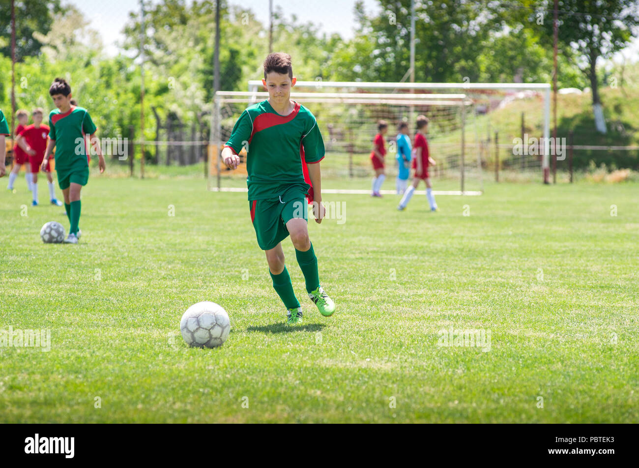 boys kicking football on the sports field Stock Photo - Alamy
