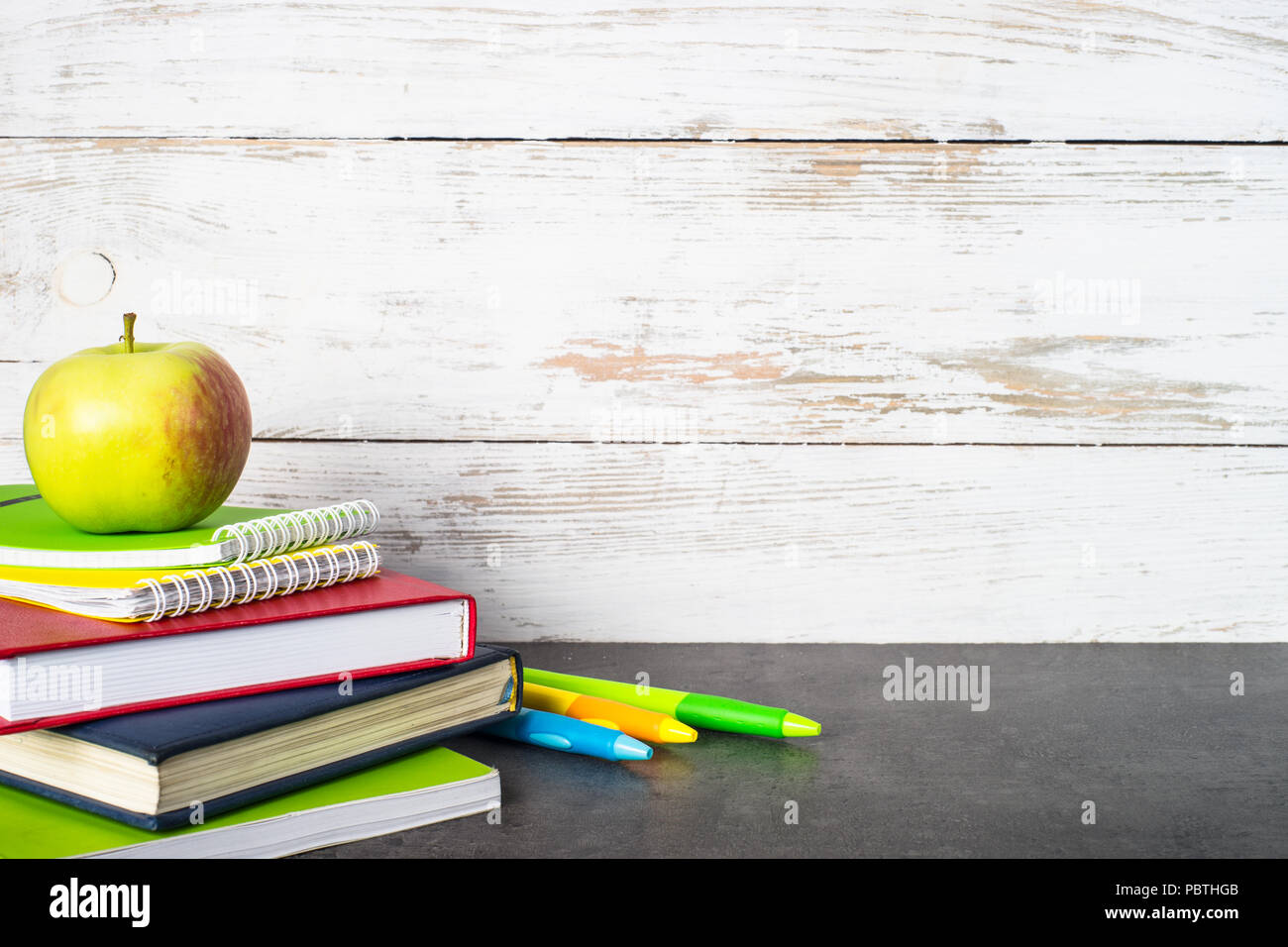 Stack of books, notebook, pen and apple Stock Photo - Alamy