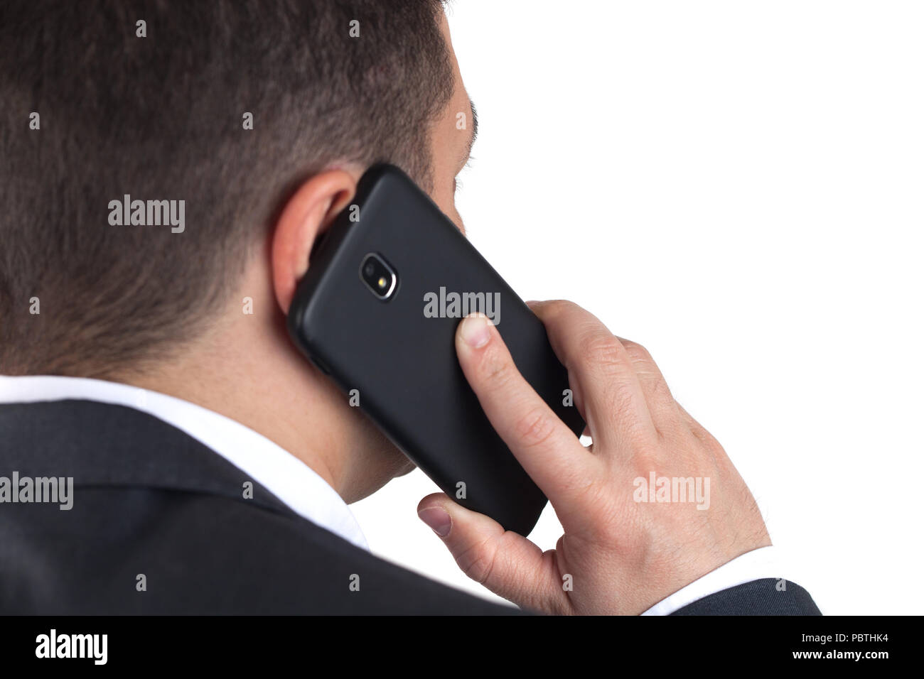portrait of serious young attractive man in black suit talking on ...