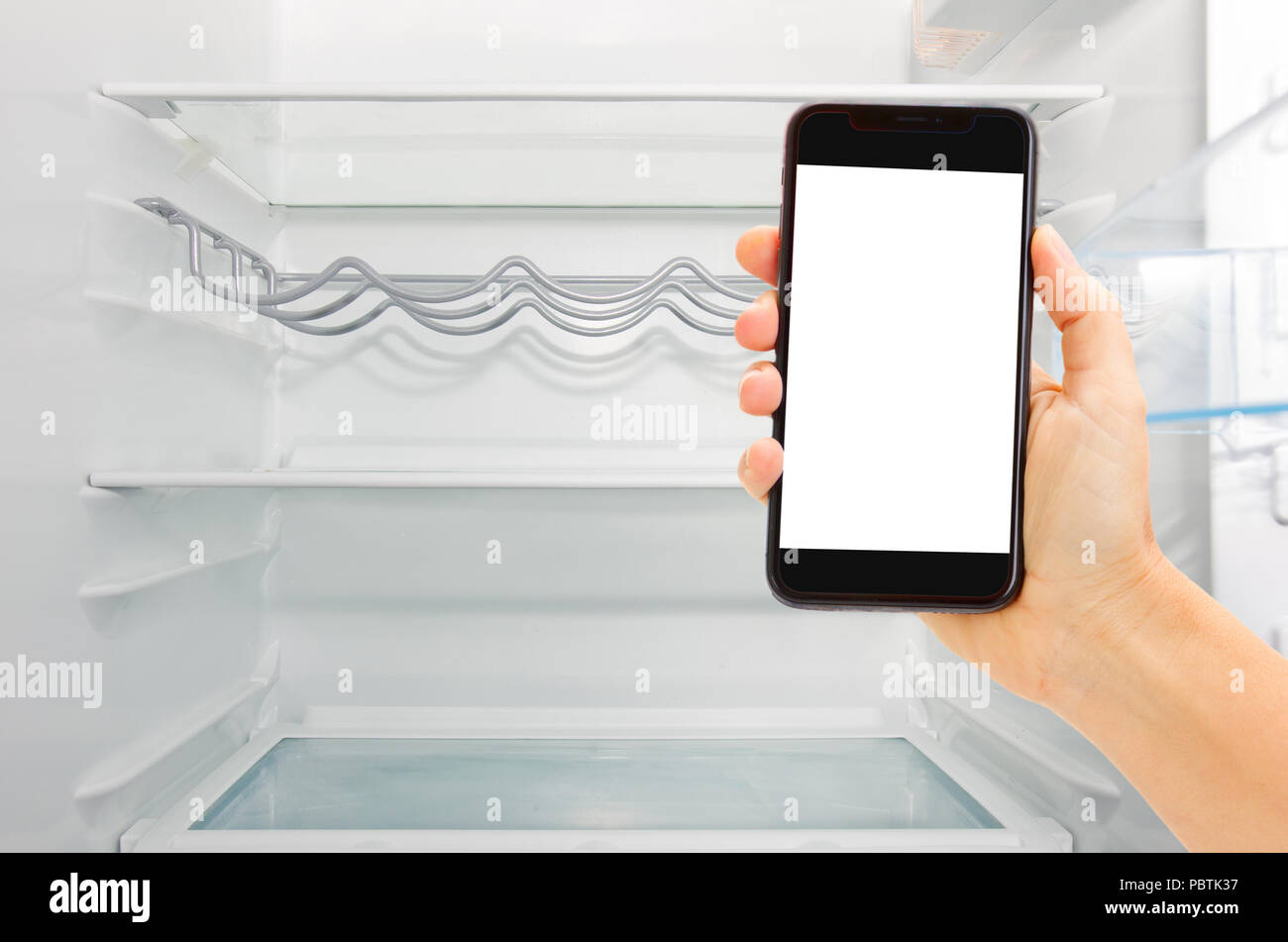 empty white open fridge with hand holding modern phone with copy space ...