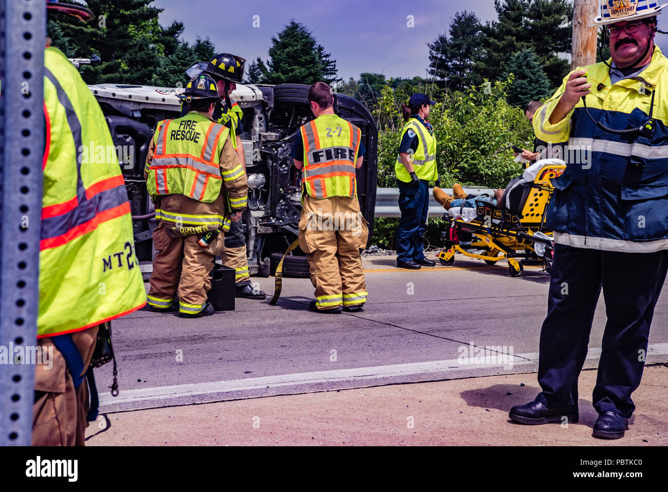 Overturned car at traffic accident scene near major highway on ramp ...