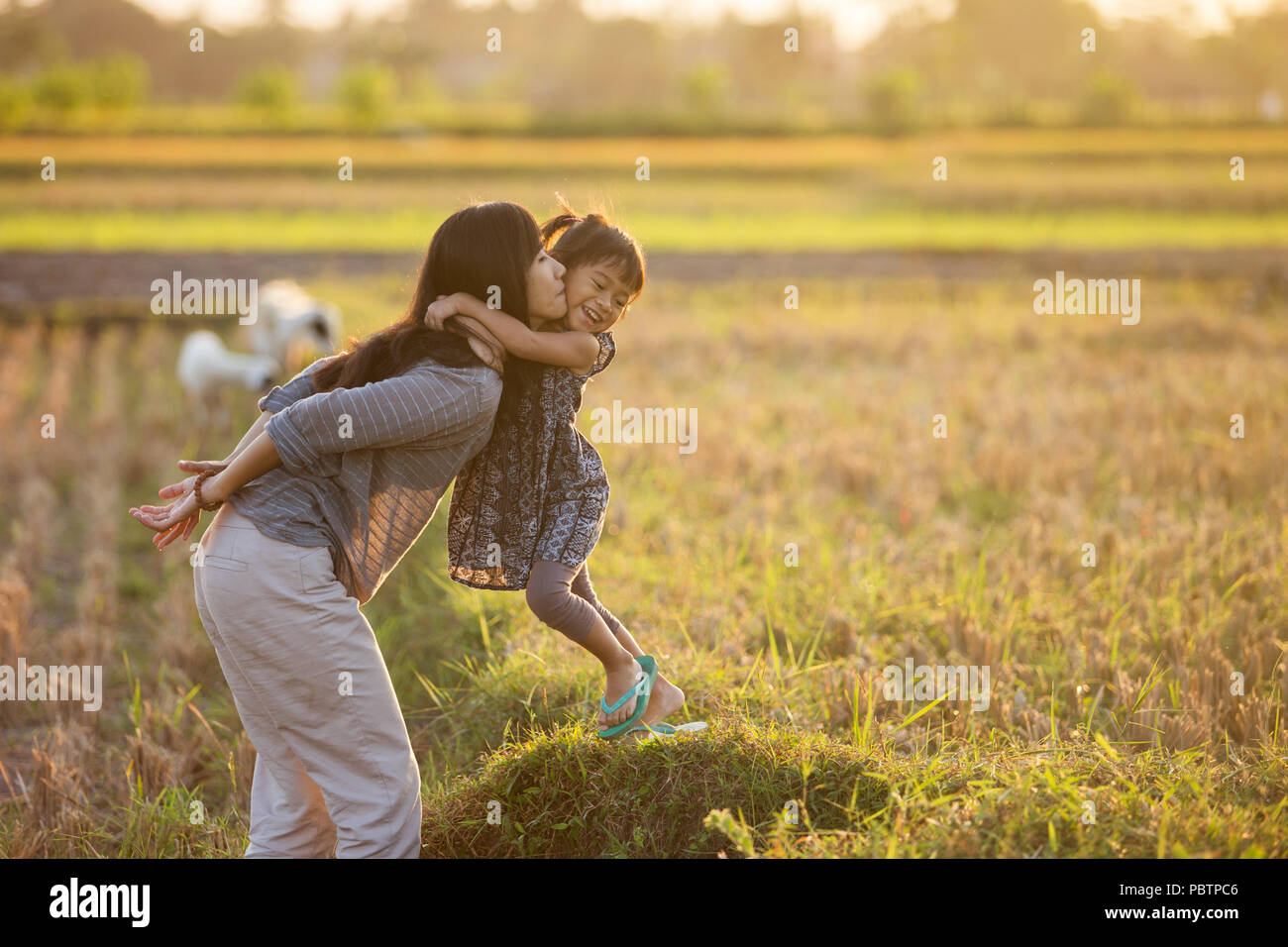 mom and kid hugging under the sunset sky Stock Photo - Alamy
