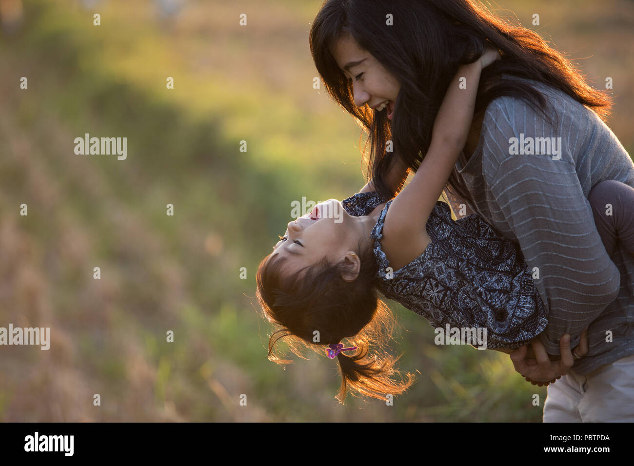 mom and kid hugging under the sunset sky Stock Photo - Alamy