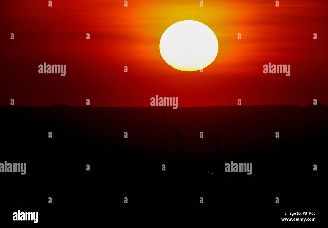 Detail of the sun hiding at dusk after a hill in the west of Hermosillo ...