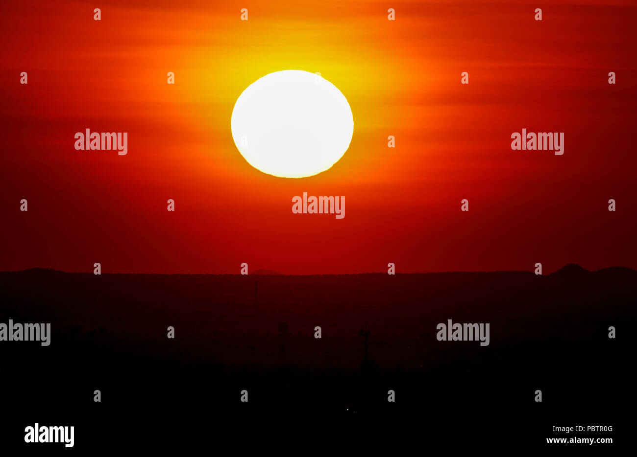 Detail of the sun hiding at dusk after a hill in the west of Hermosillo ...