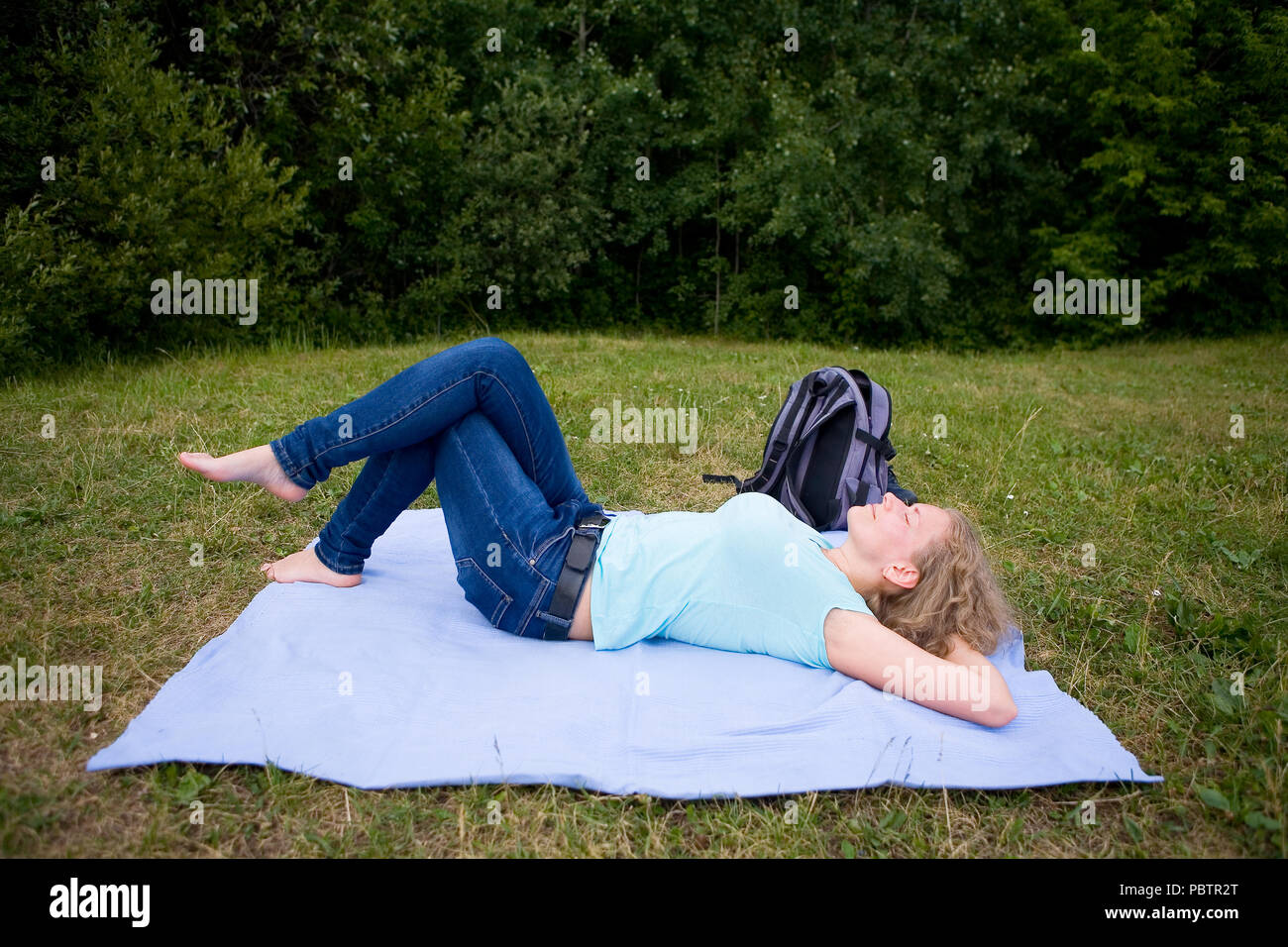 A woman is resting on the ground. Human and nature Stock Photo - Alamy