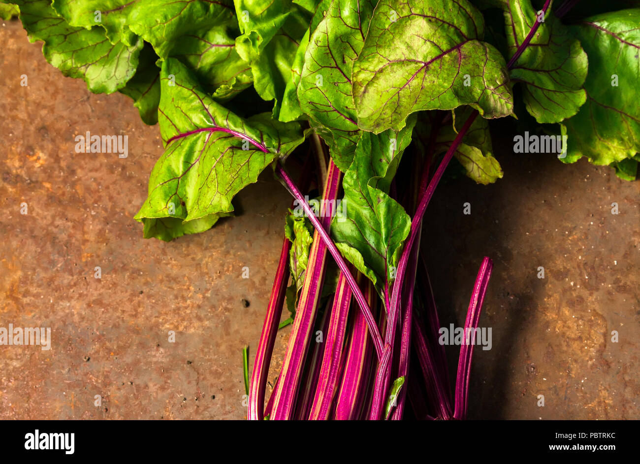 Red beet leaves on textured background Stock Photo - Alamy