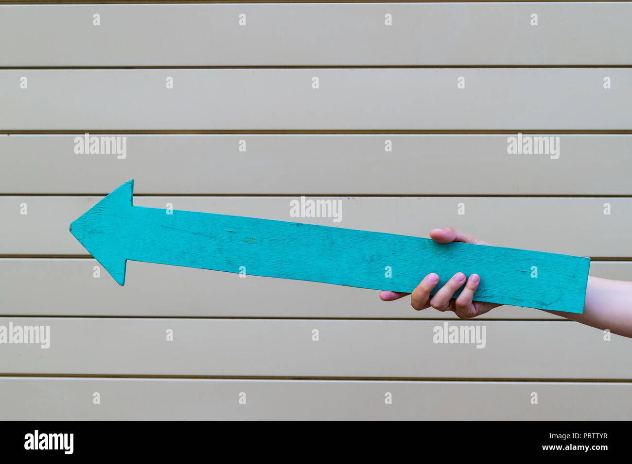 Hand holding a blue arrow pointer Stock Photo - Alamy