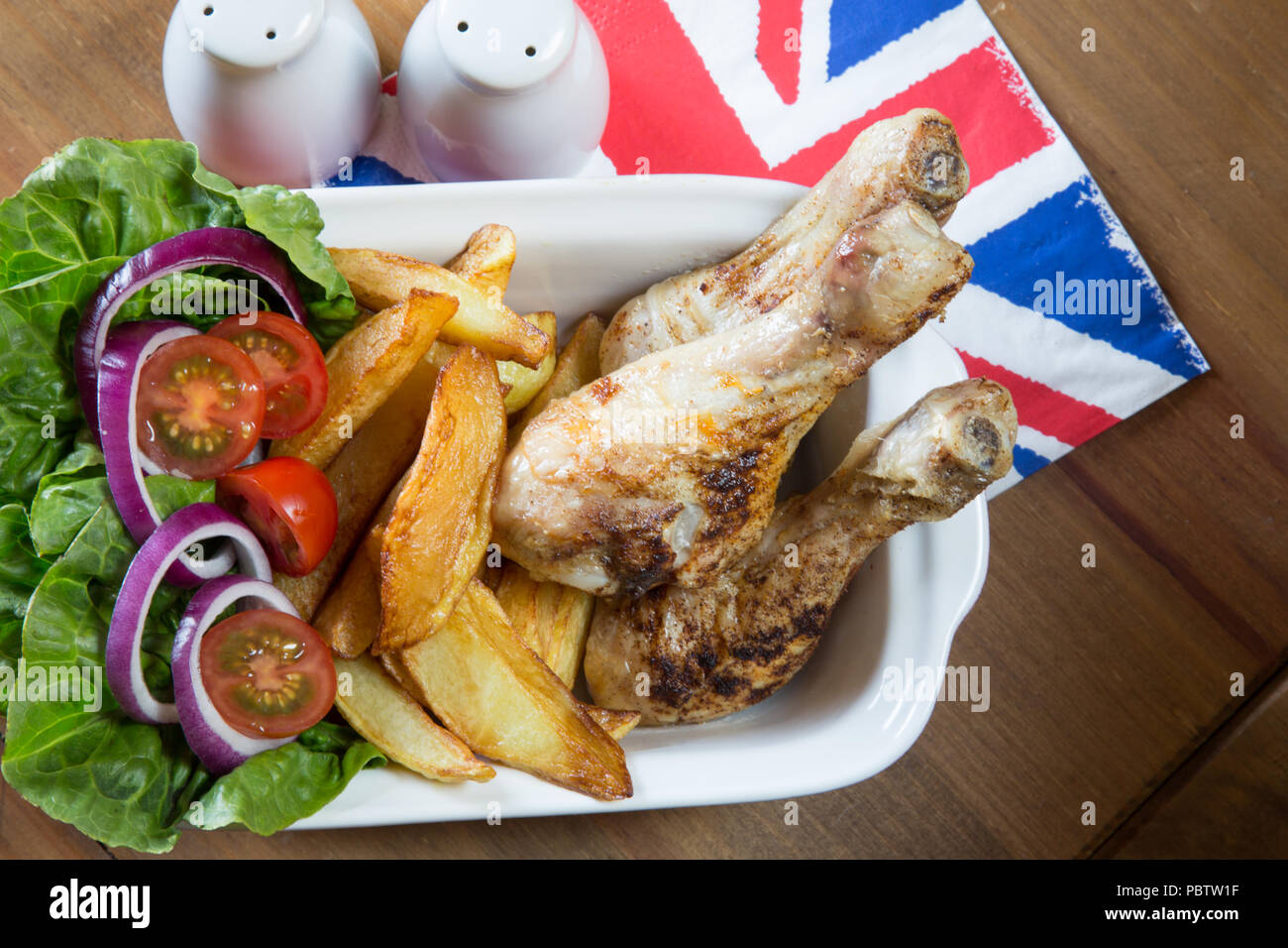English pub meal of Roast Chicken drumsticks with chips/fries and a ...