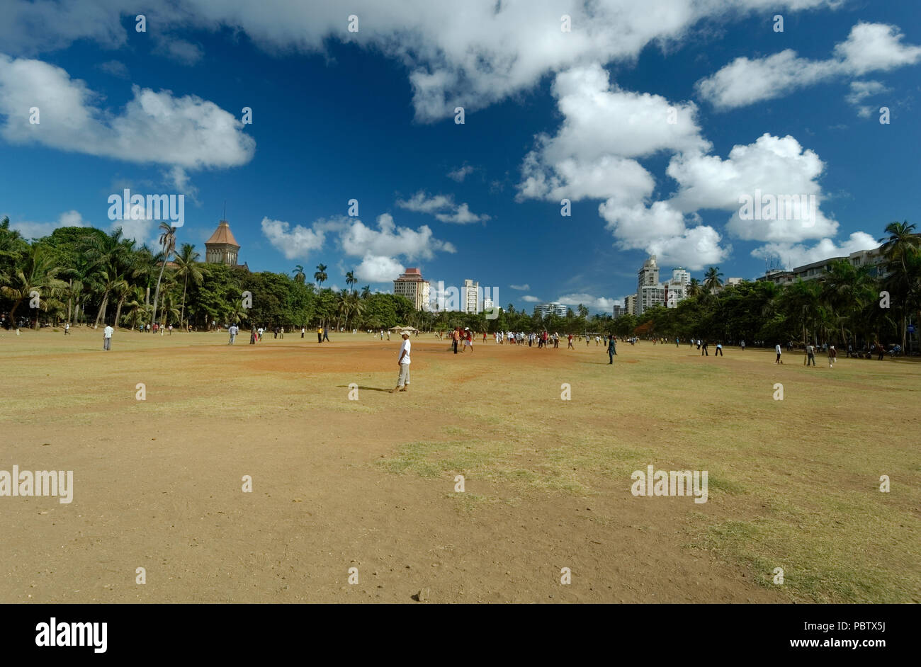 Boys playing Cricket in the background of Rajabai Tower historic clock ...