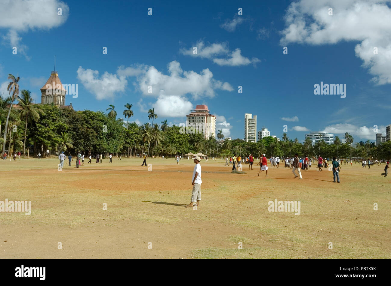 Boys playing Cricket in the background of Rajabai Tower historic clock ...