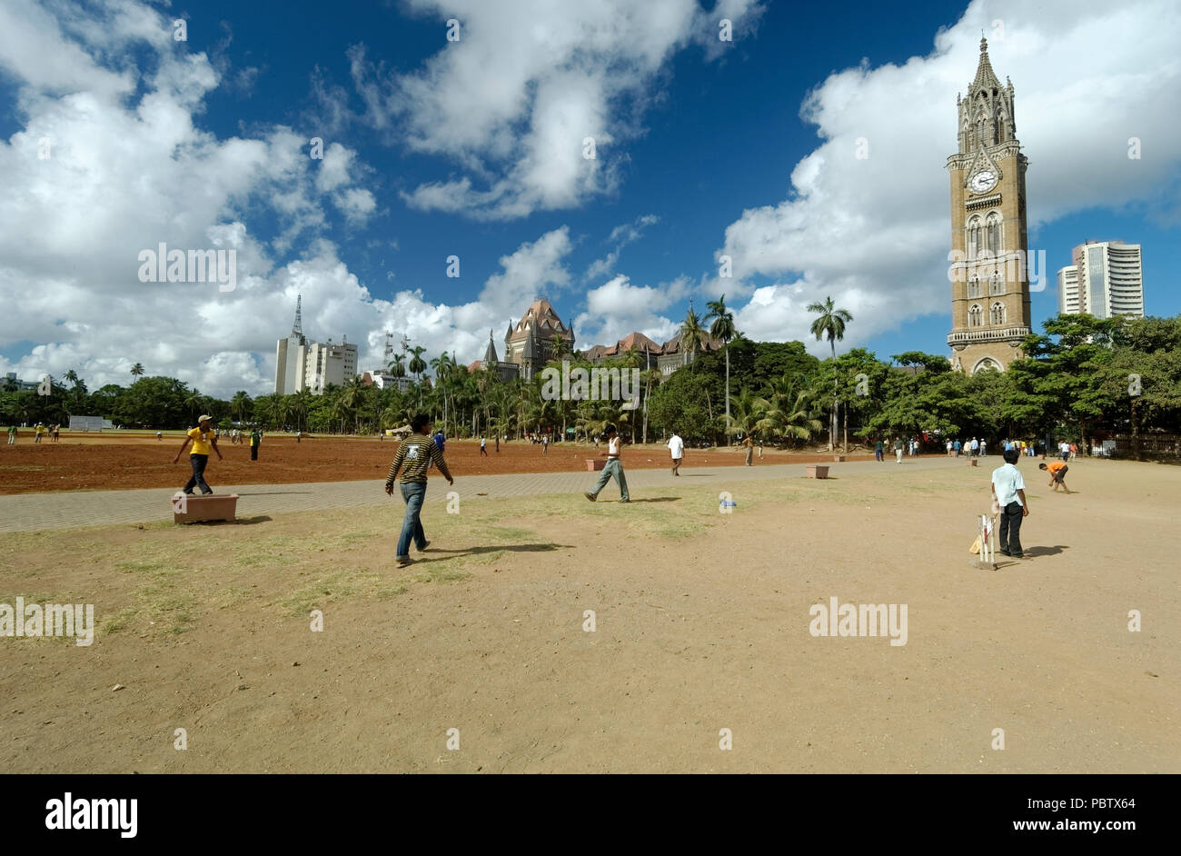 Boys playing Cricket in the background of Rajabai Tower historic clock ...