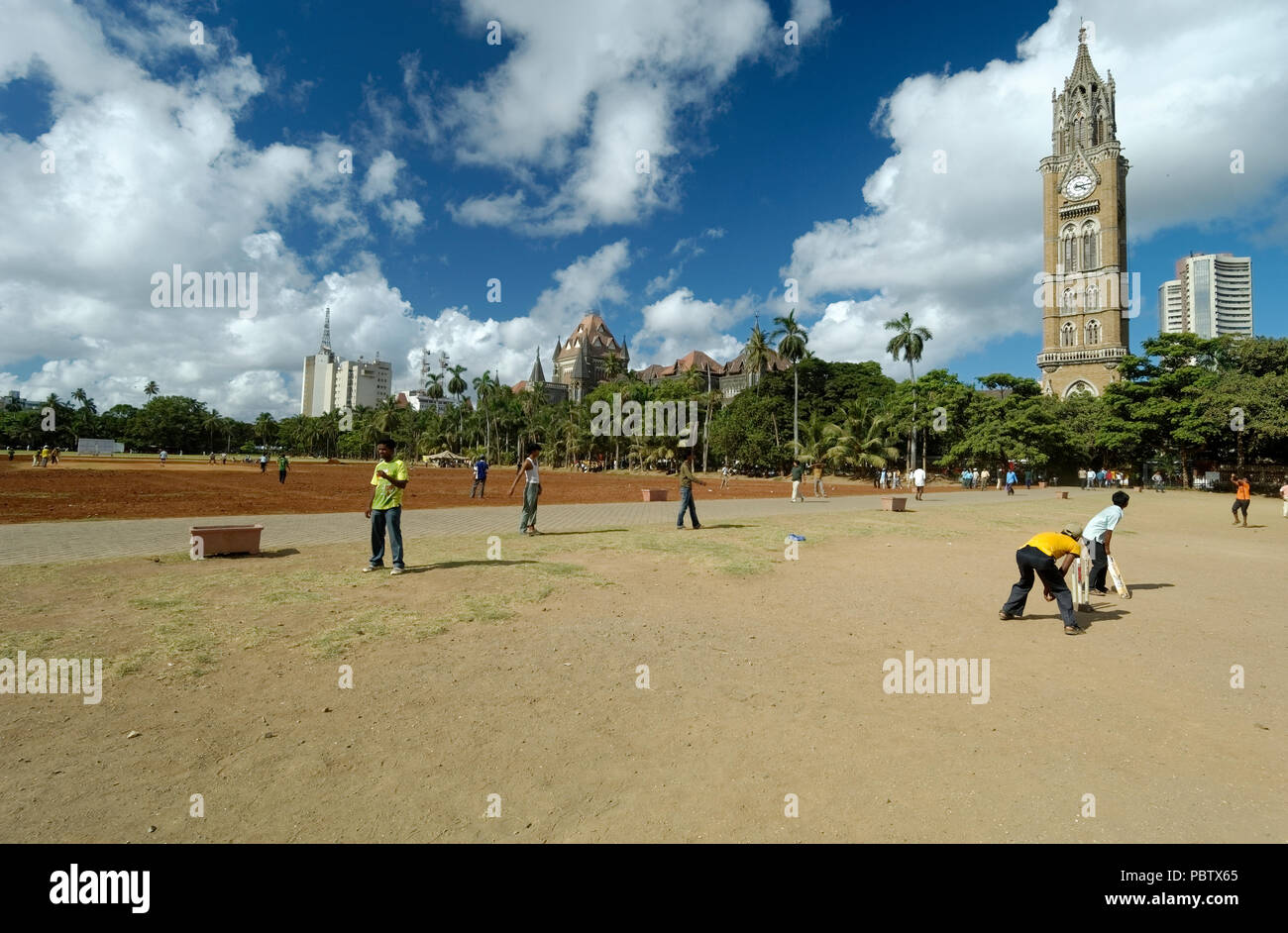 Boys playing Cricket in the background of Rajabai Tower historic clock ...
