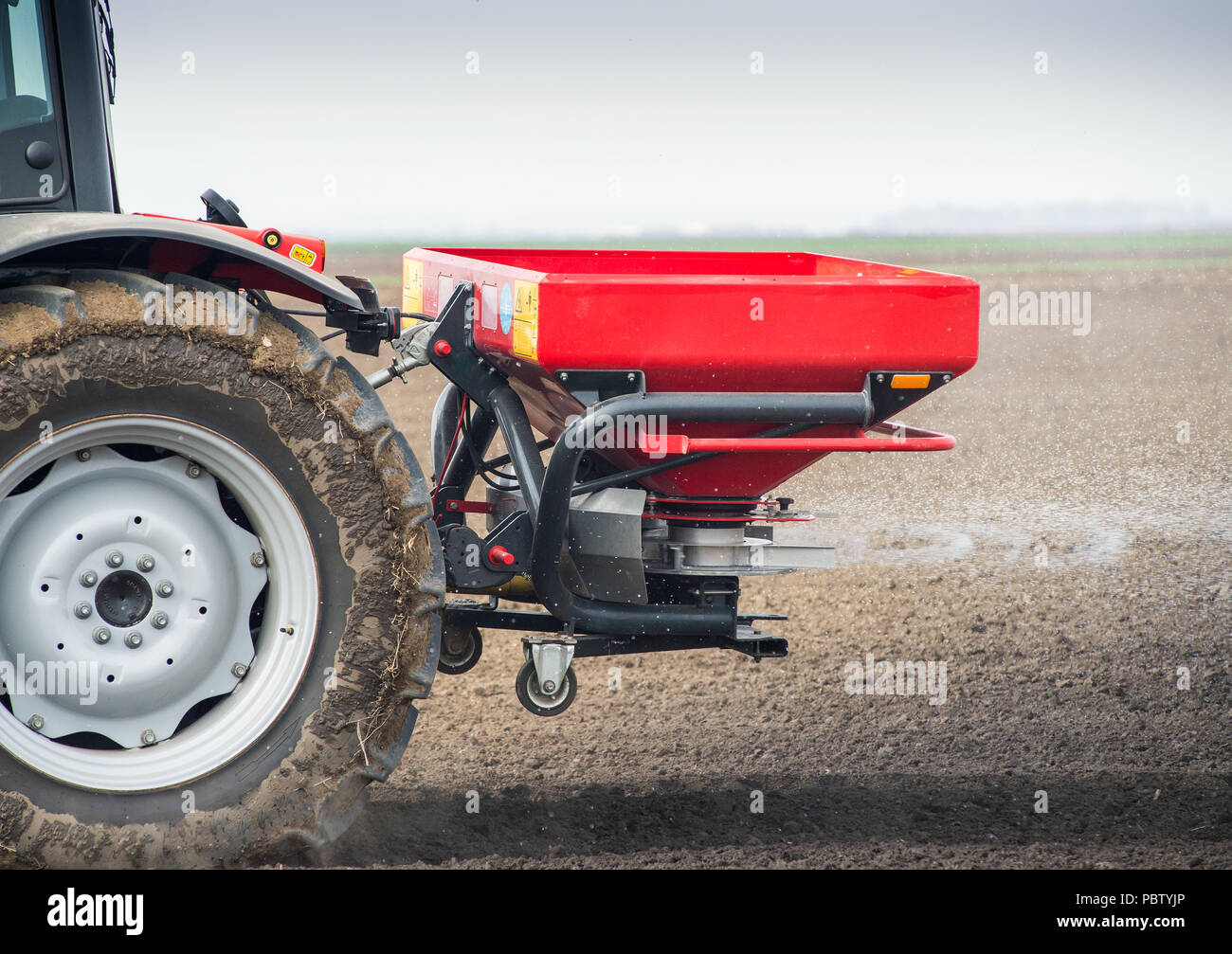 Tractor and fertilizer spreader in field Stock Photo - Alamy
