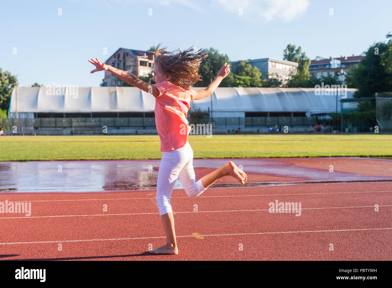 Happy girl run on the track Stock Photo - Alamy
