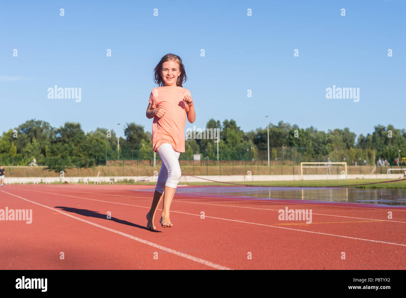 Happy girl run on the track Stock Photo - Alamy