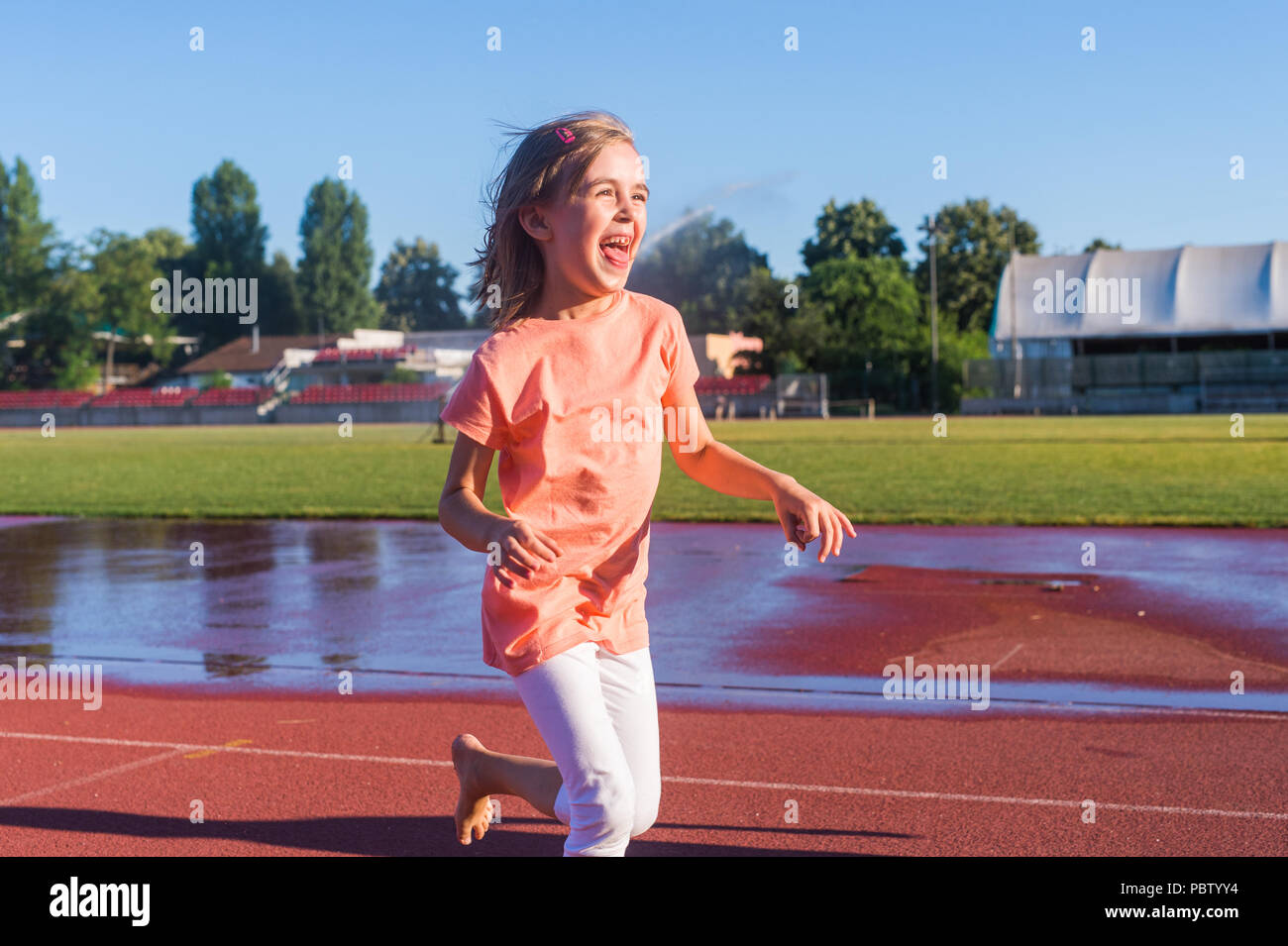 Happy girl run on the track Stock Photo - Alamy