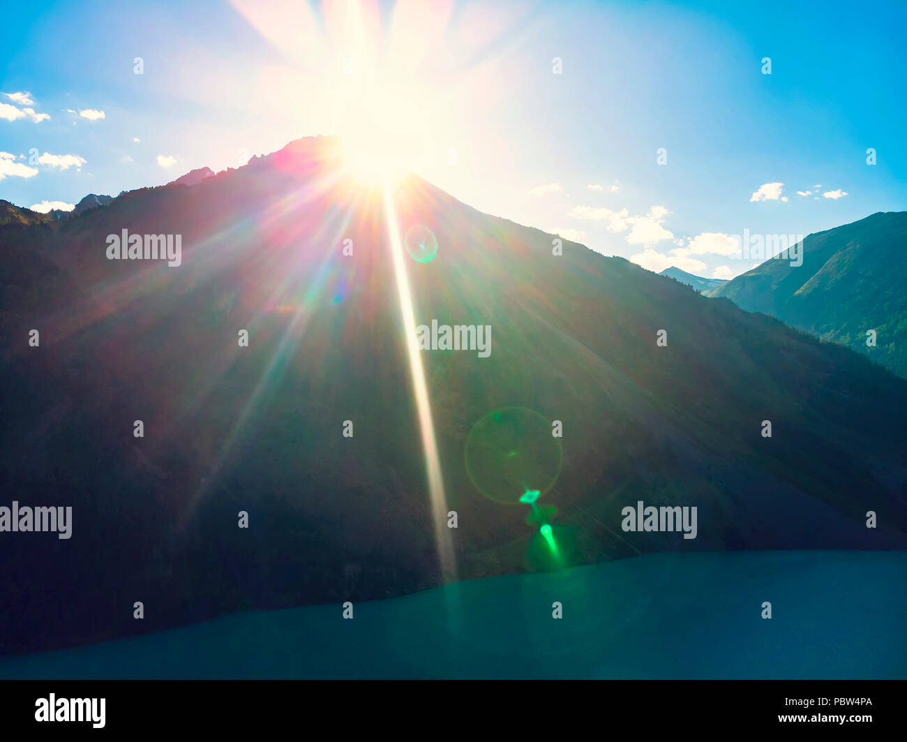 Bright orange sun rays over mountain lake. Sunrise over the mountain ...