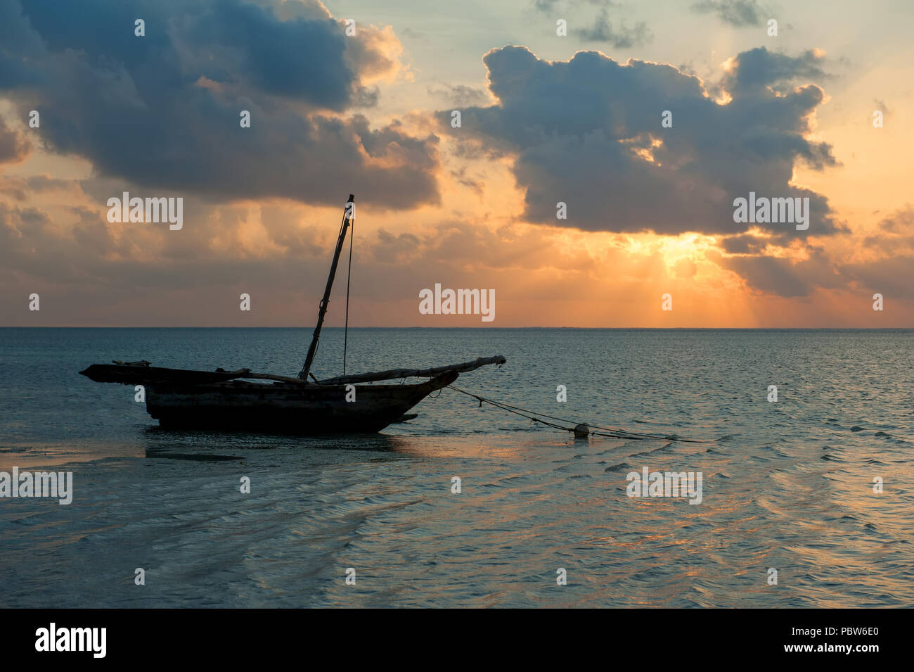 Beautiful tropical sunset with boat in ocean Stock Photo - Alamy