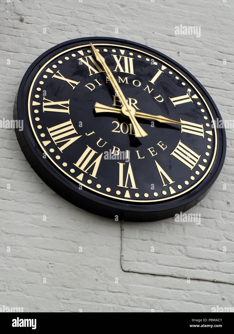 Diamond Jubilee clock on shopfront in the traditional English village ...