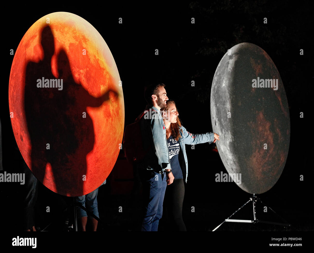 People enjoy a photographic simulation of a total lunar eclipse in the ...