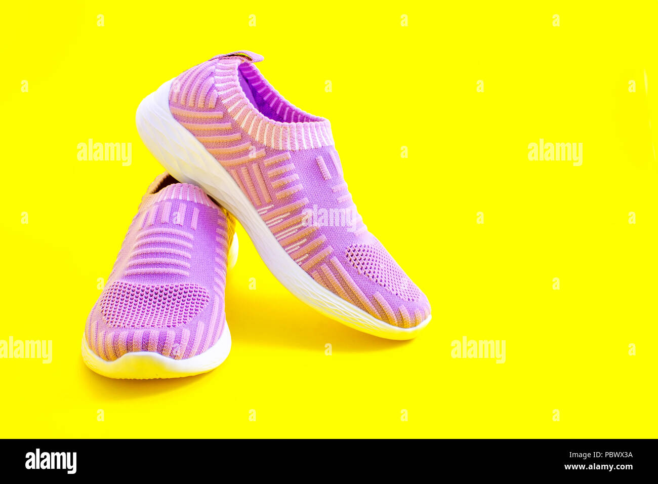 purple sport shoes on a yellow background Stock Photo - Alamy